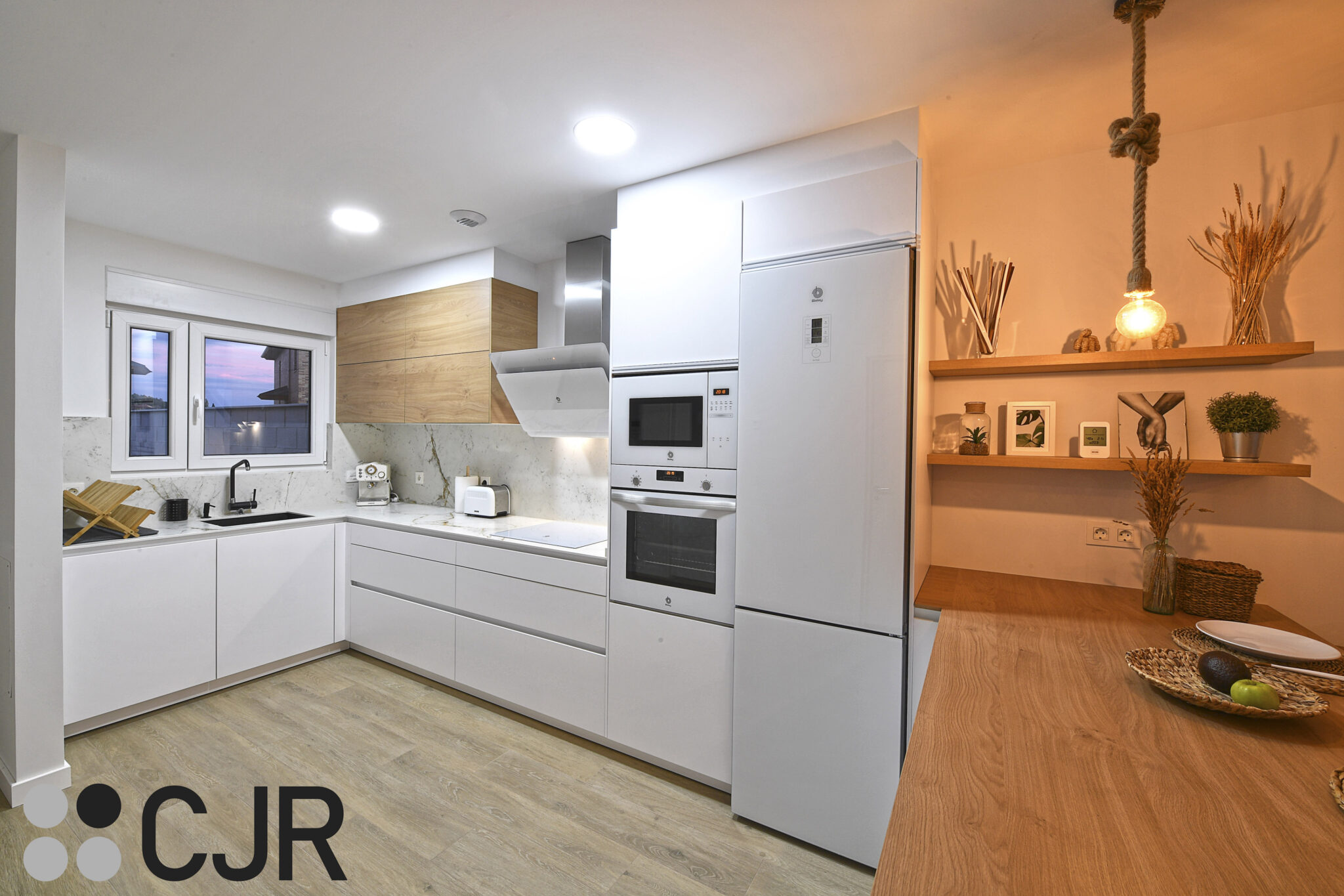 Cocina con peninsula abierta al salon blanca y madera CJR | Cocinas CJR Santos