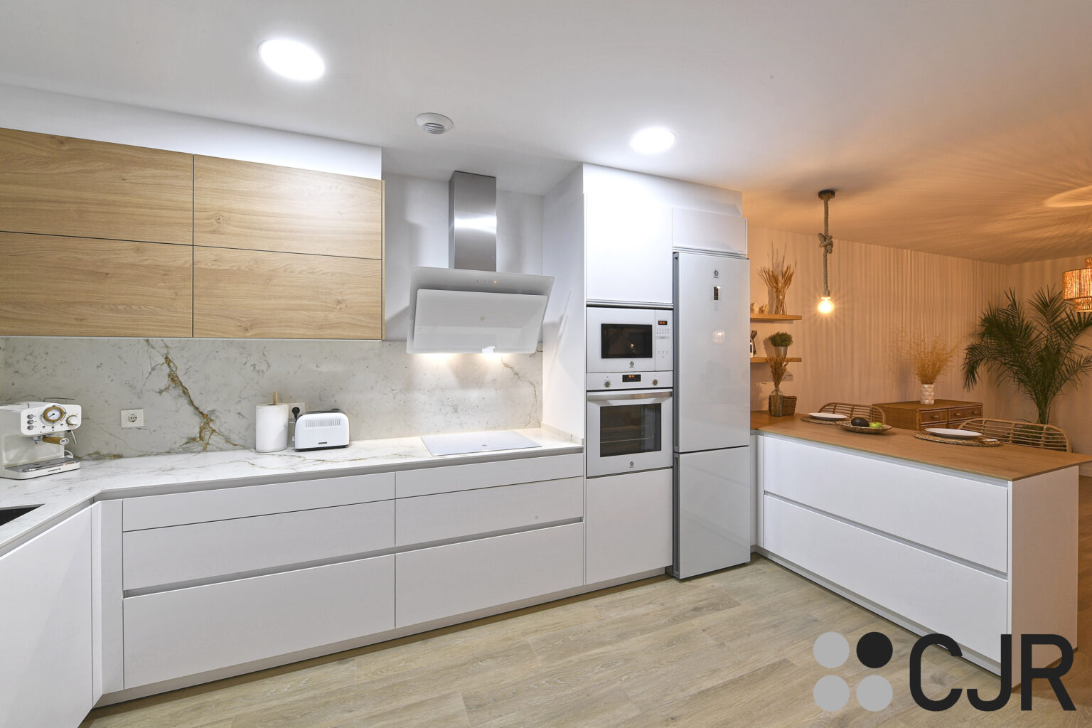 Cocina con peninsula abierta al salon blanca y madera CJR | Cocinas CJR Santos