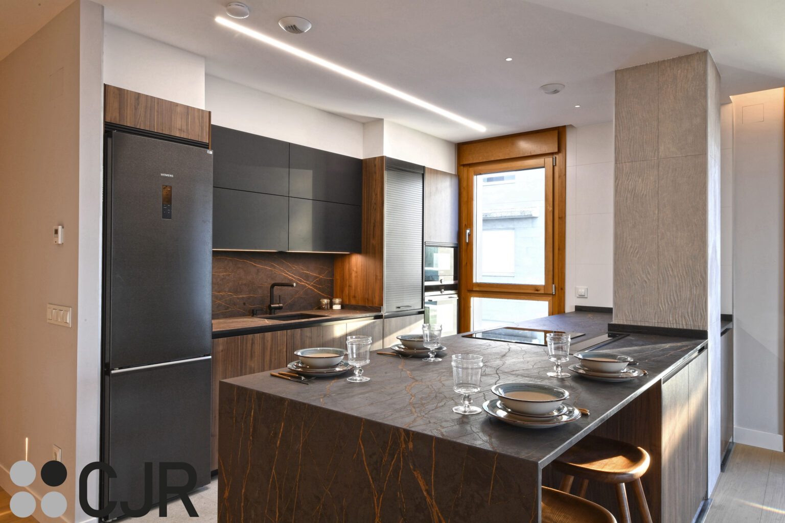 Cocina abierta madera y negra con peninsula CJR | Cocinas CJR Santos
